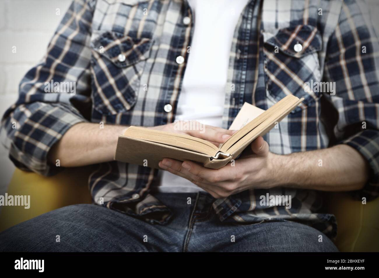 Young man reading book, close-up, on light background Stock Photo - Alamy