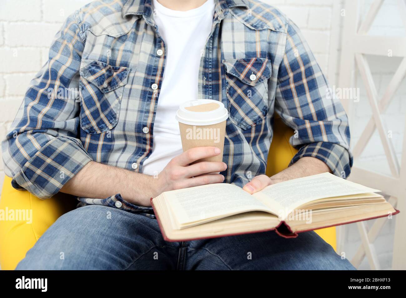 Young man reading book, close-up, on light background Stock Photo - Alamy