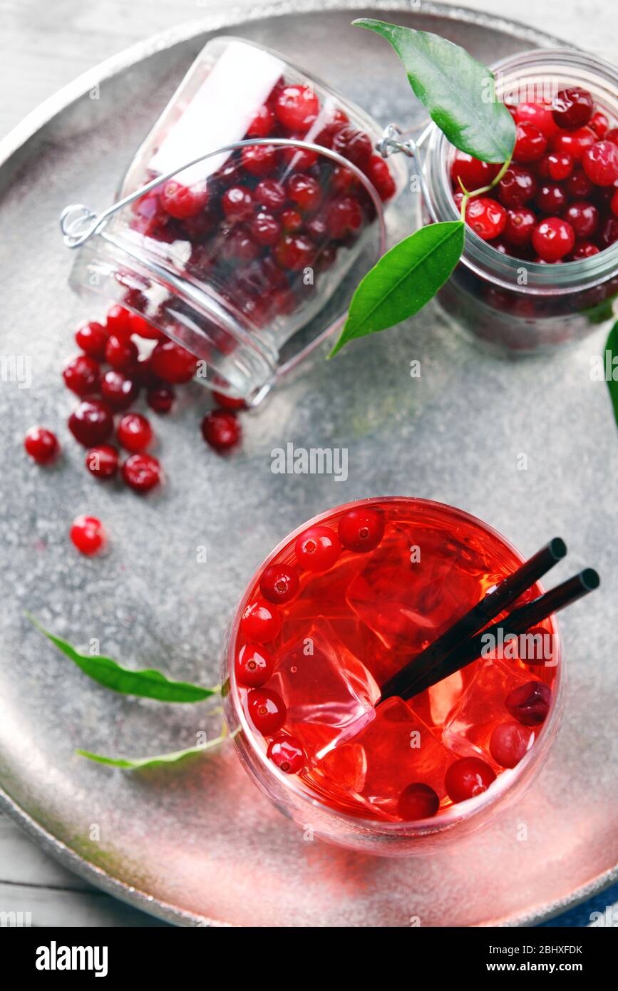 Compote with red currant in glassware on metal tray on wooden table ...