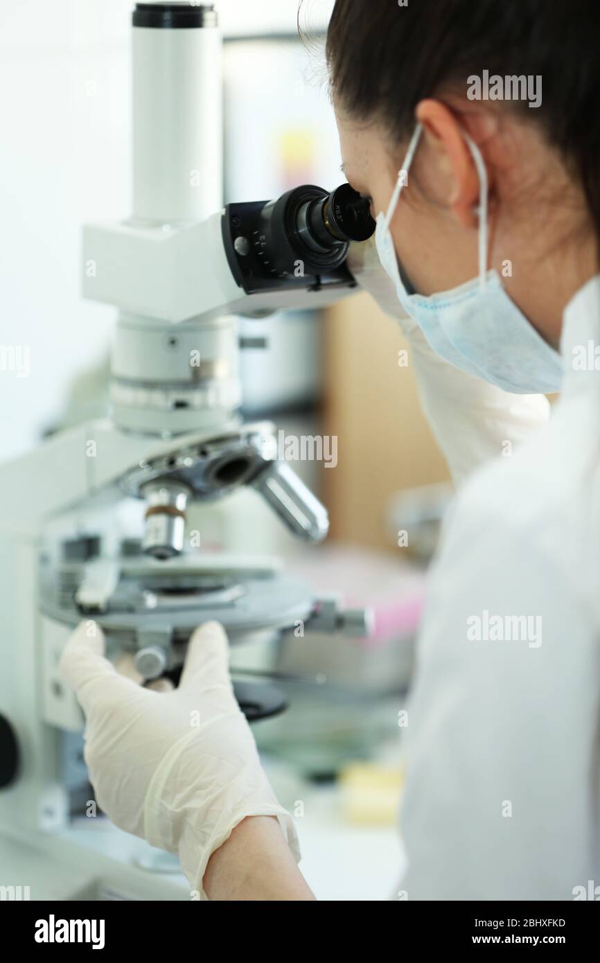 Female scientist looking through a microscope in laboratory Stock Photo ...