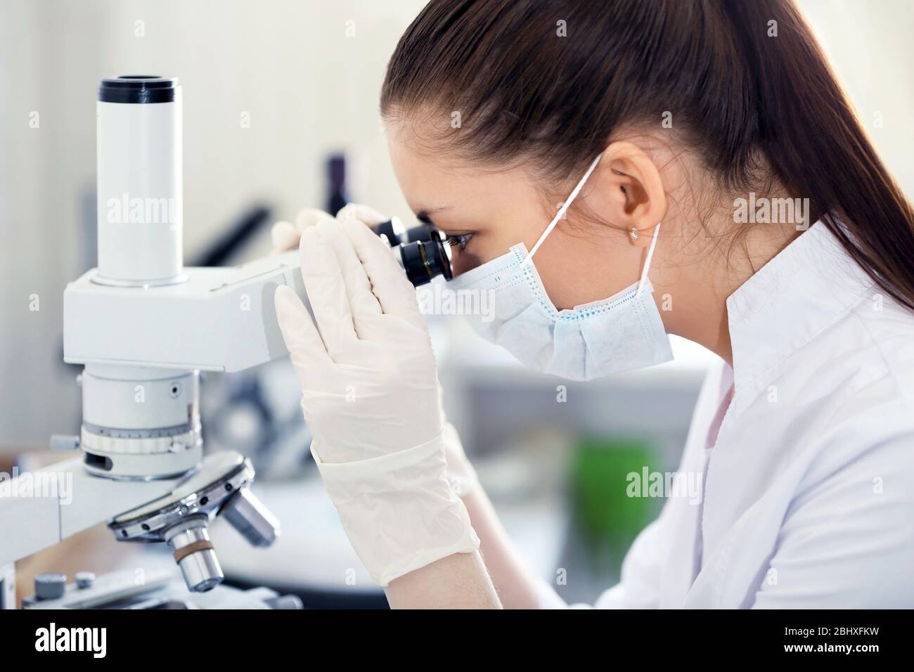 Female scientist looking through a microscope in laboratory Stock Photo ...