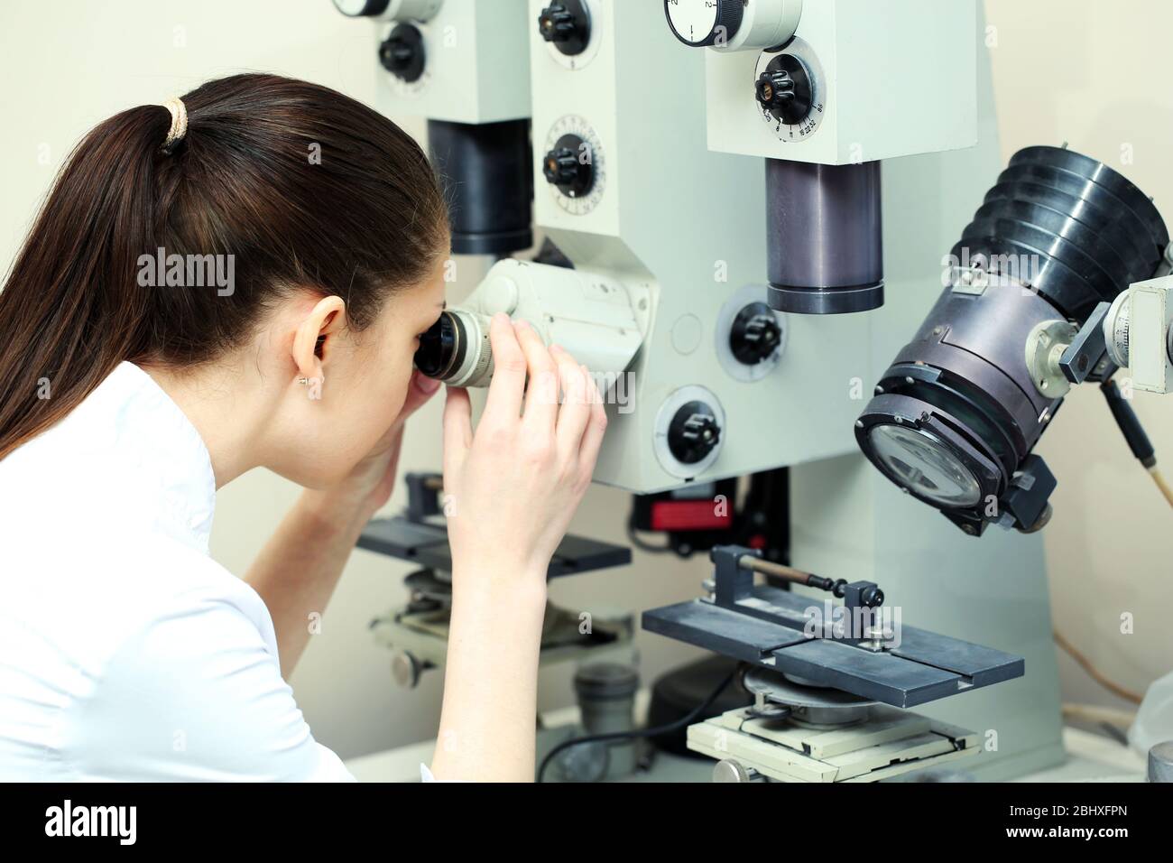 Female scientist looking through a microscope in laboratory Stock Photo ...