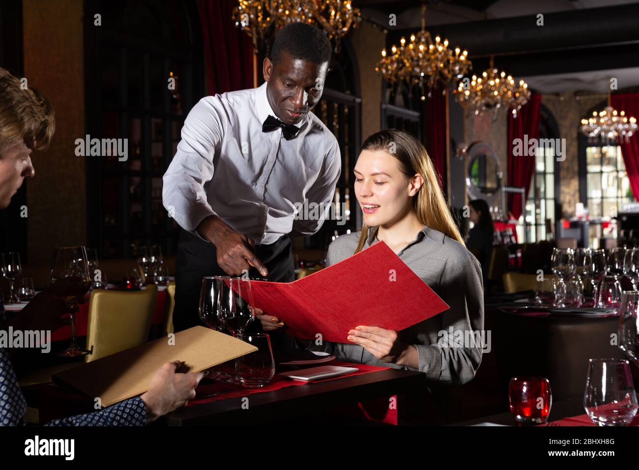 Positive couple having dinner in luxury restaurant and making order ...
