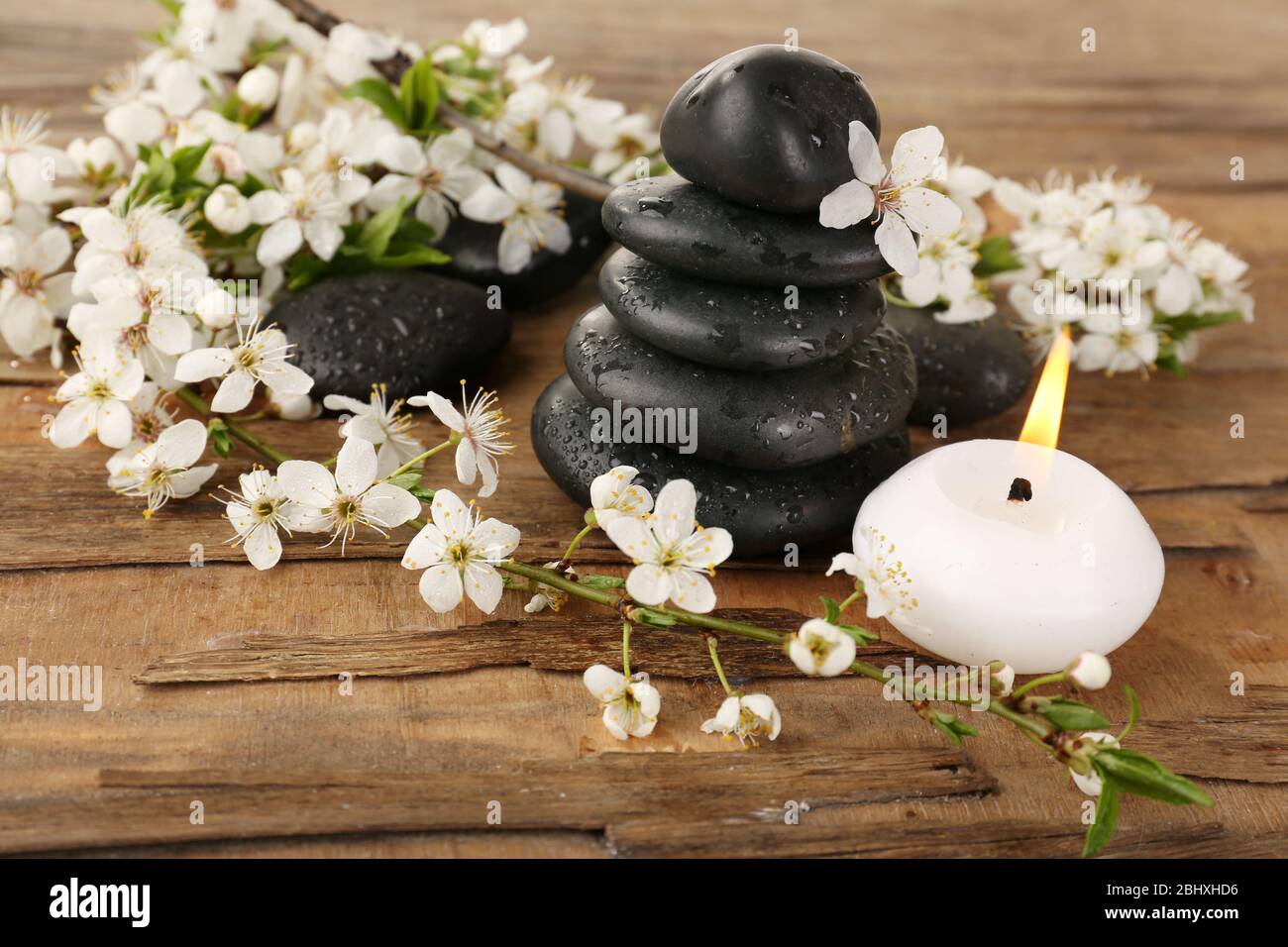 Spa stones with candle and spring flowers on wooden background Stock ...