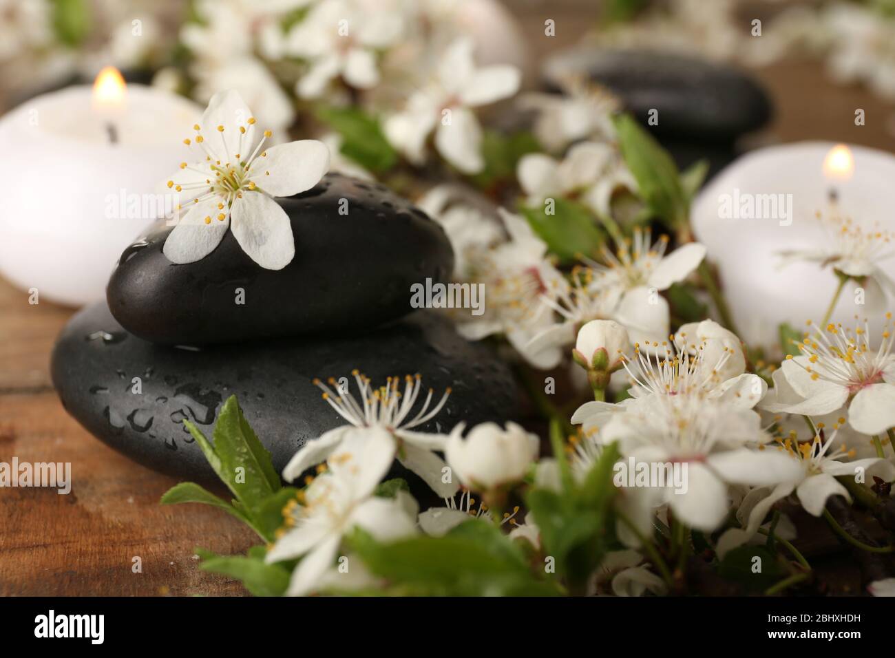 Spa stones with candles and spring flowers on table close up Stock ...
