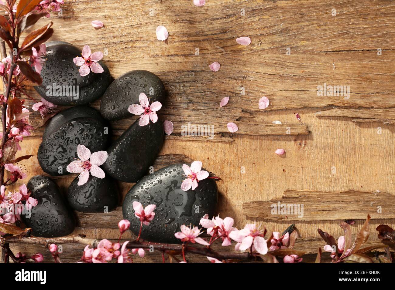 Spa stones with spring flowers on table close up Stock Photo - Alamy