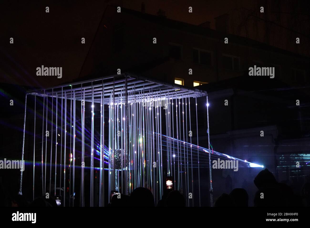 Metal cube with disco ball inside illuminated with many lights around ...