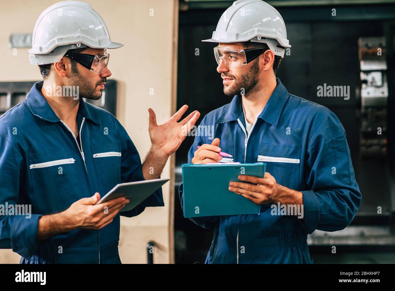 Engineer teamwork cooperate with worker to checking factory machine for ...