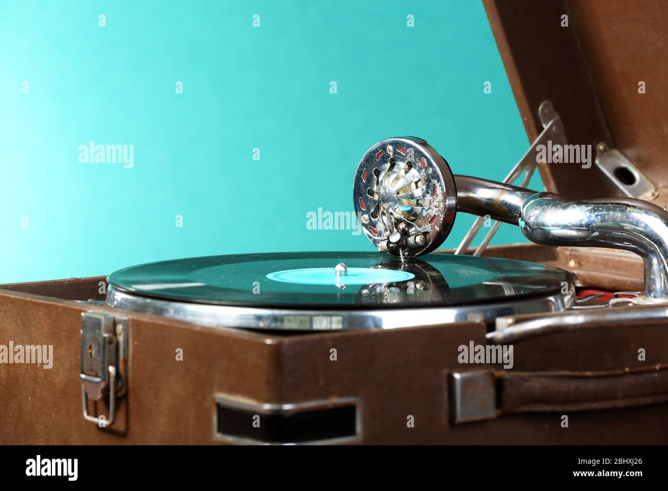 Gramophone with vinyl record on table on green background Stock Photo ...