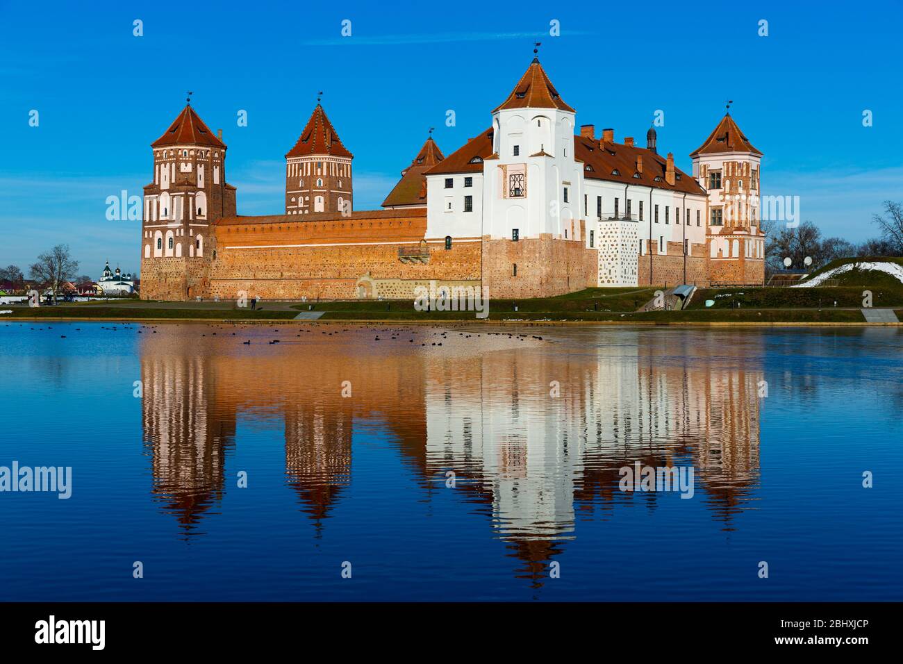 Scenic winter landscape with historic fortified Mir Castle on bank of ...