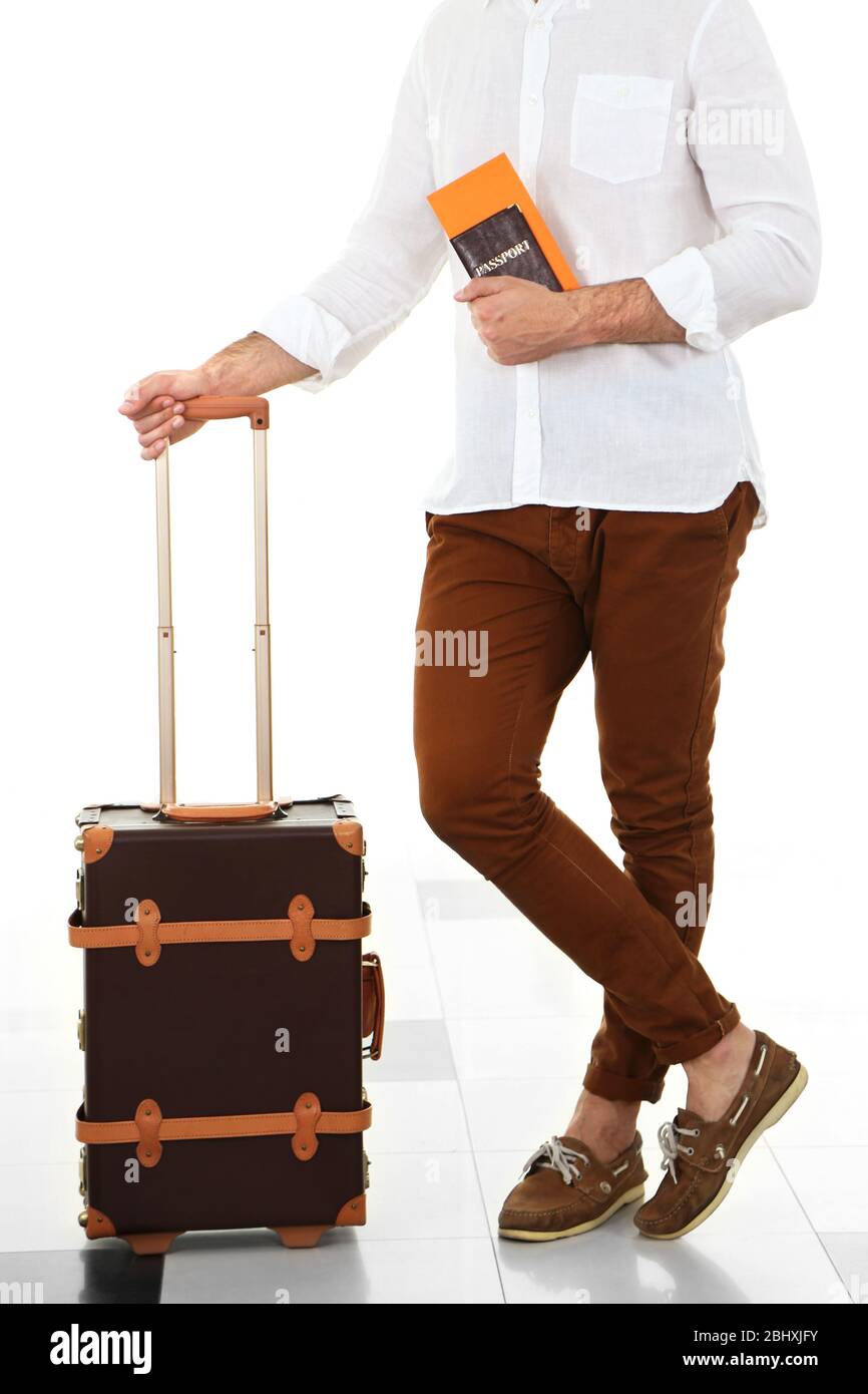 Man holding suitcase in airport Stock Photo - Alamy