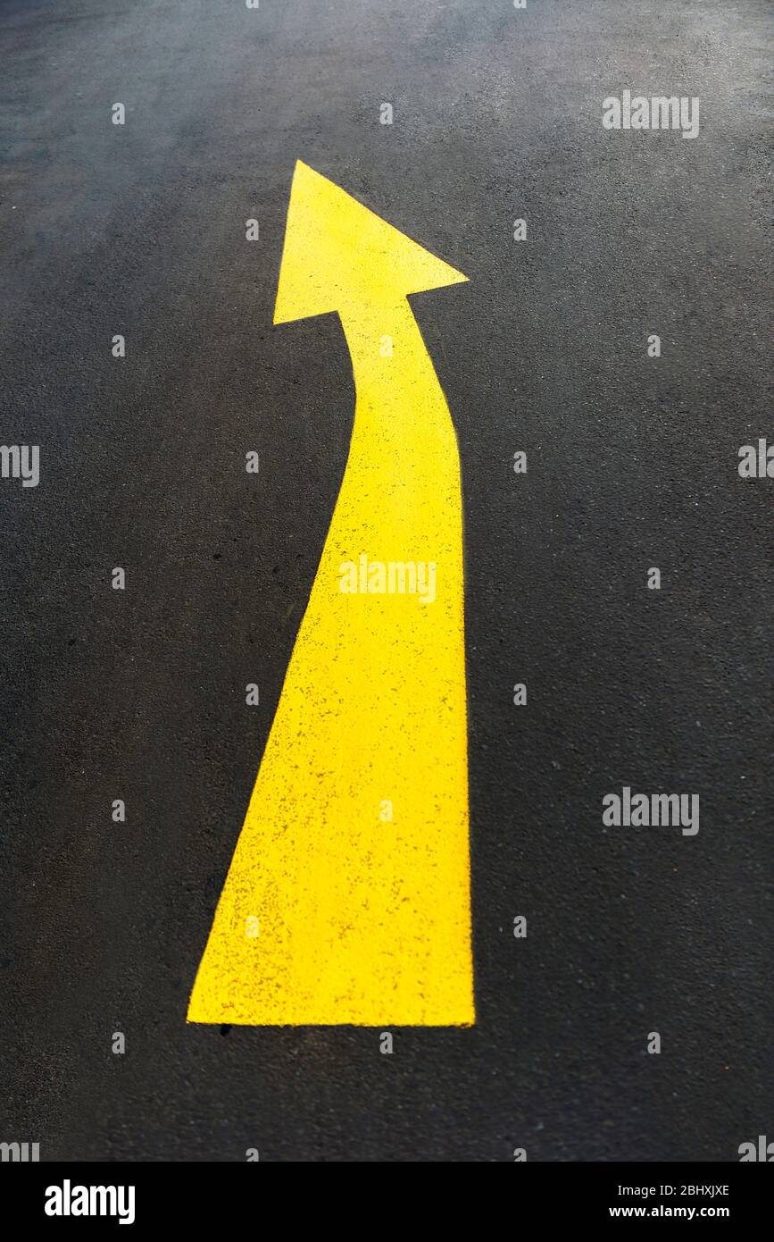 Yellow arrows with a turn to the left sign in asphalt road Stock Photo ...
