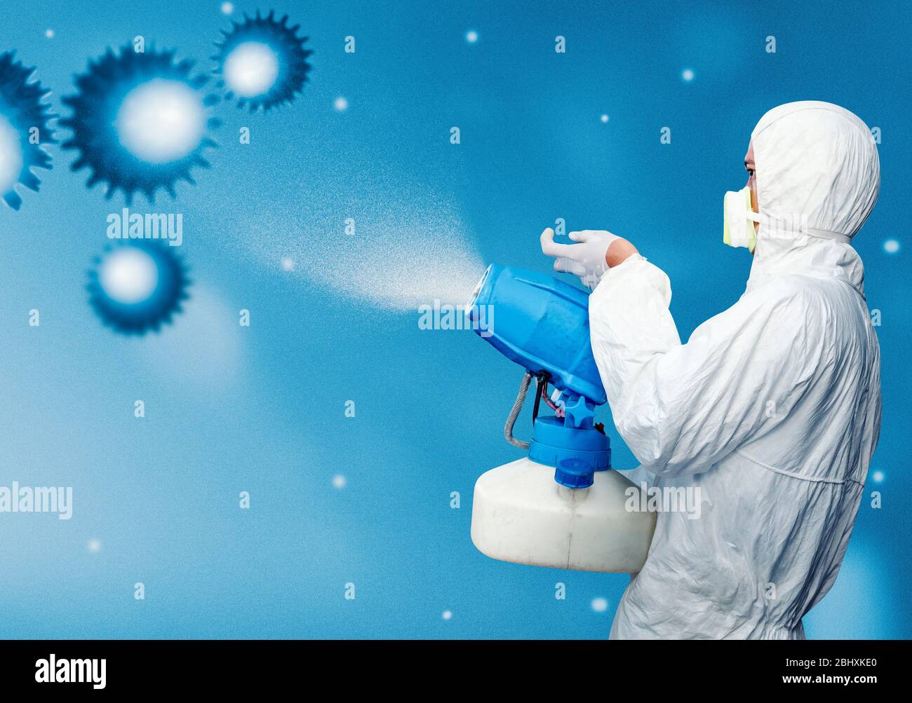 Man in a white protective suit spraying disinfectant in the air ...