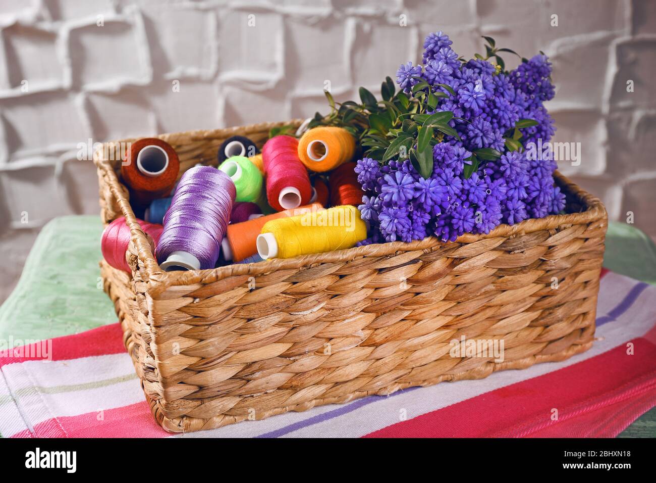 Beautiful muscari - hyacinth in wicker basket with spools of thread on ...