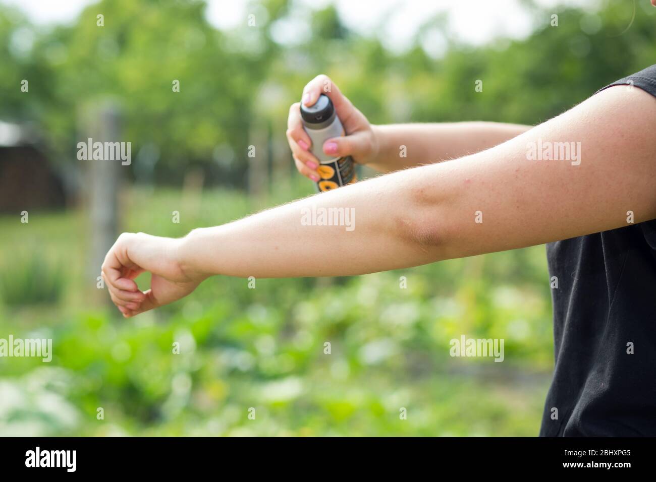 Young woman spraying mosquito, insect repellent in the forrest, insect ...