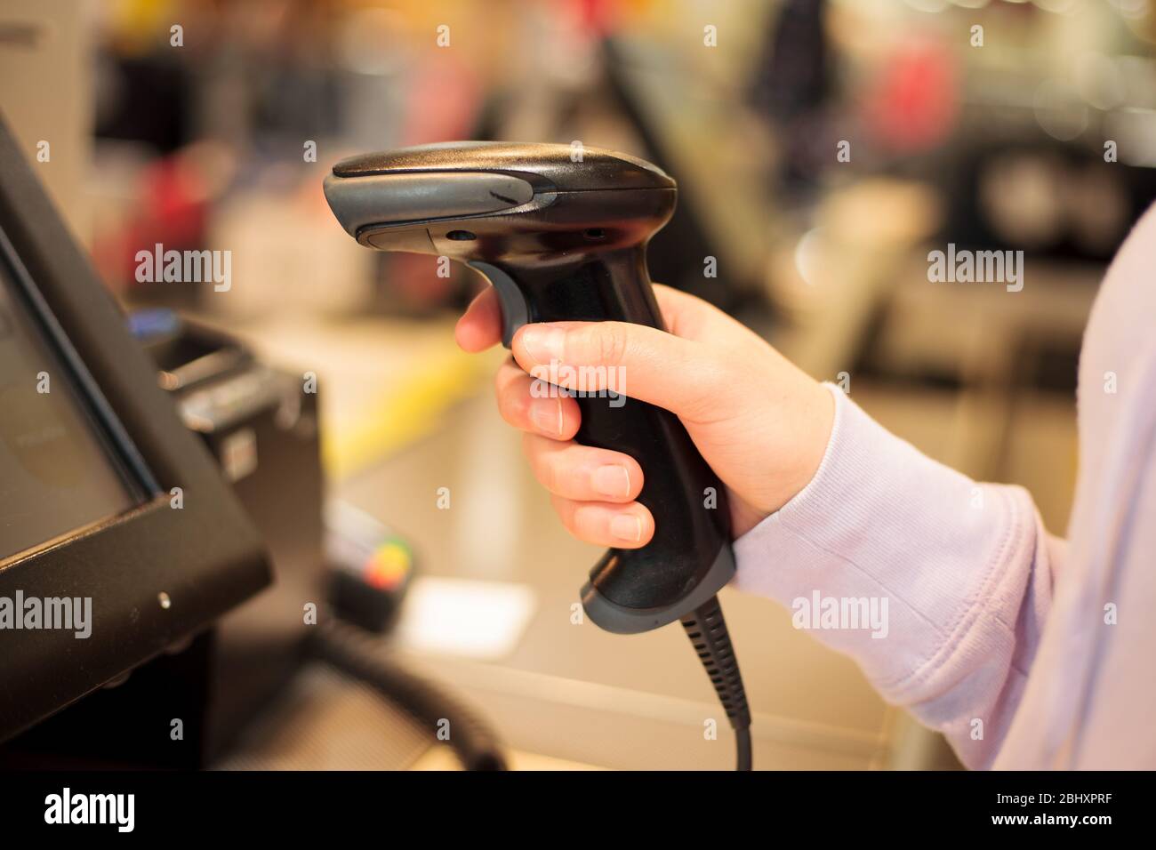 Young woman hands using scanner for scanning goods to a pos for a ...