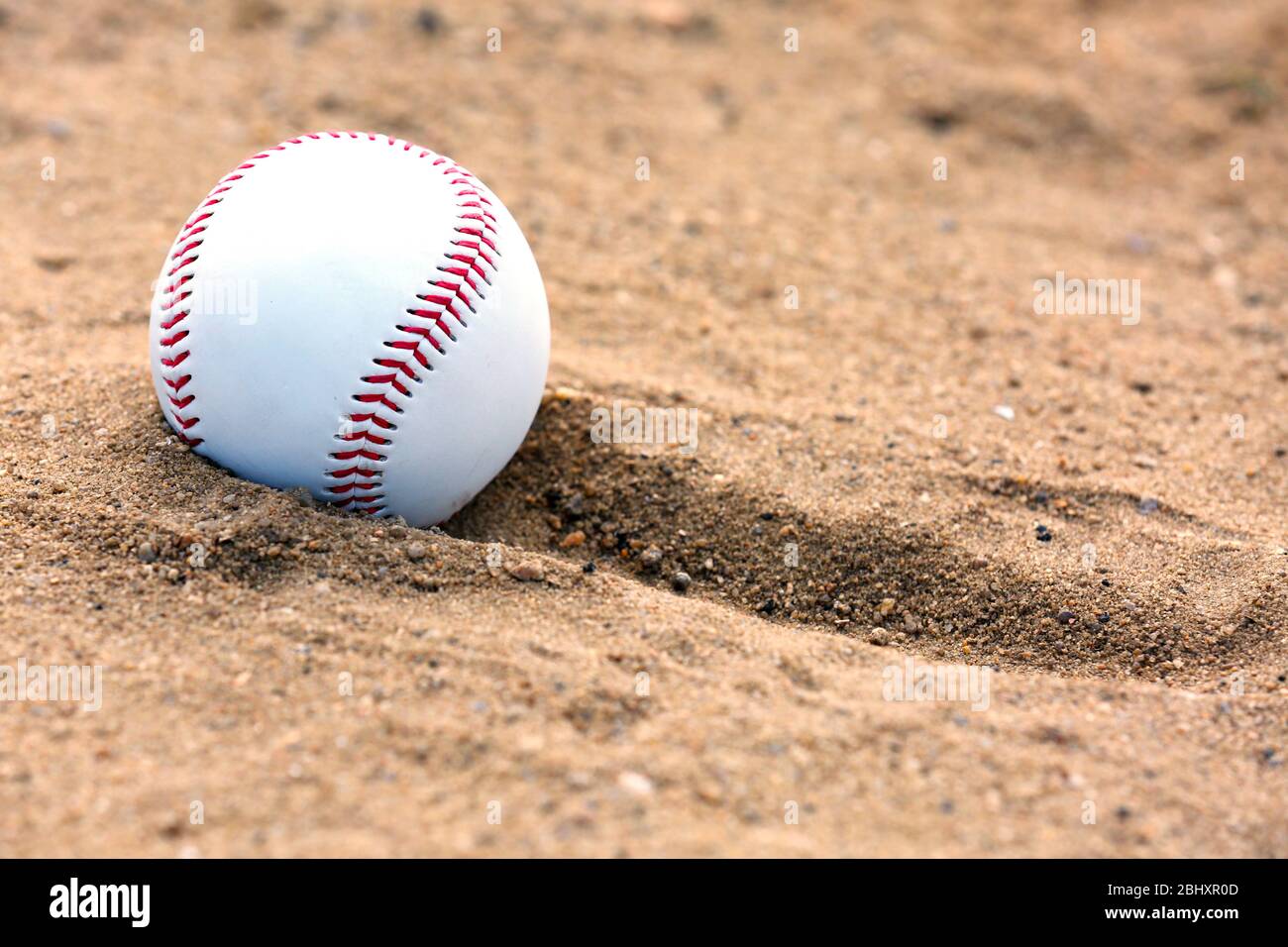Baseball ball on sand Stock Photo - Alamy