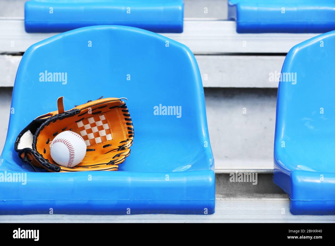 Baseball ball and glove on stadium seat Stock Photo - Alamy