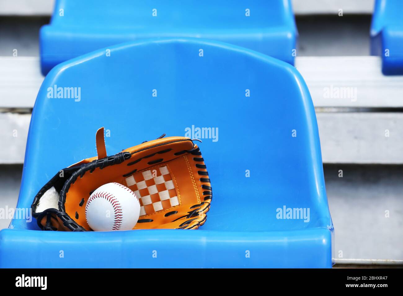 Baseball ball and glove on stadium seat Stock Photo - Alamy
