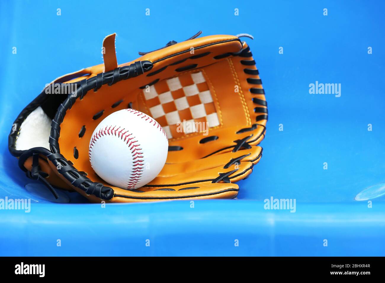 Baseball ball and glove on stadium seat Stock Photo - Alamy