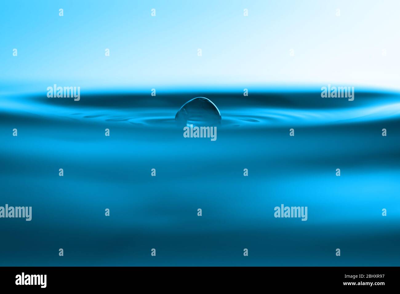 A water drop falling down onto a water surface Stock Photo - Alamy