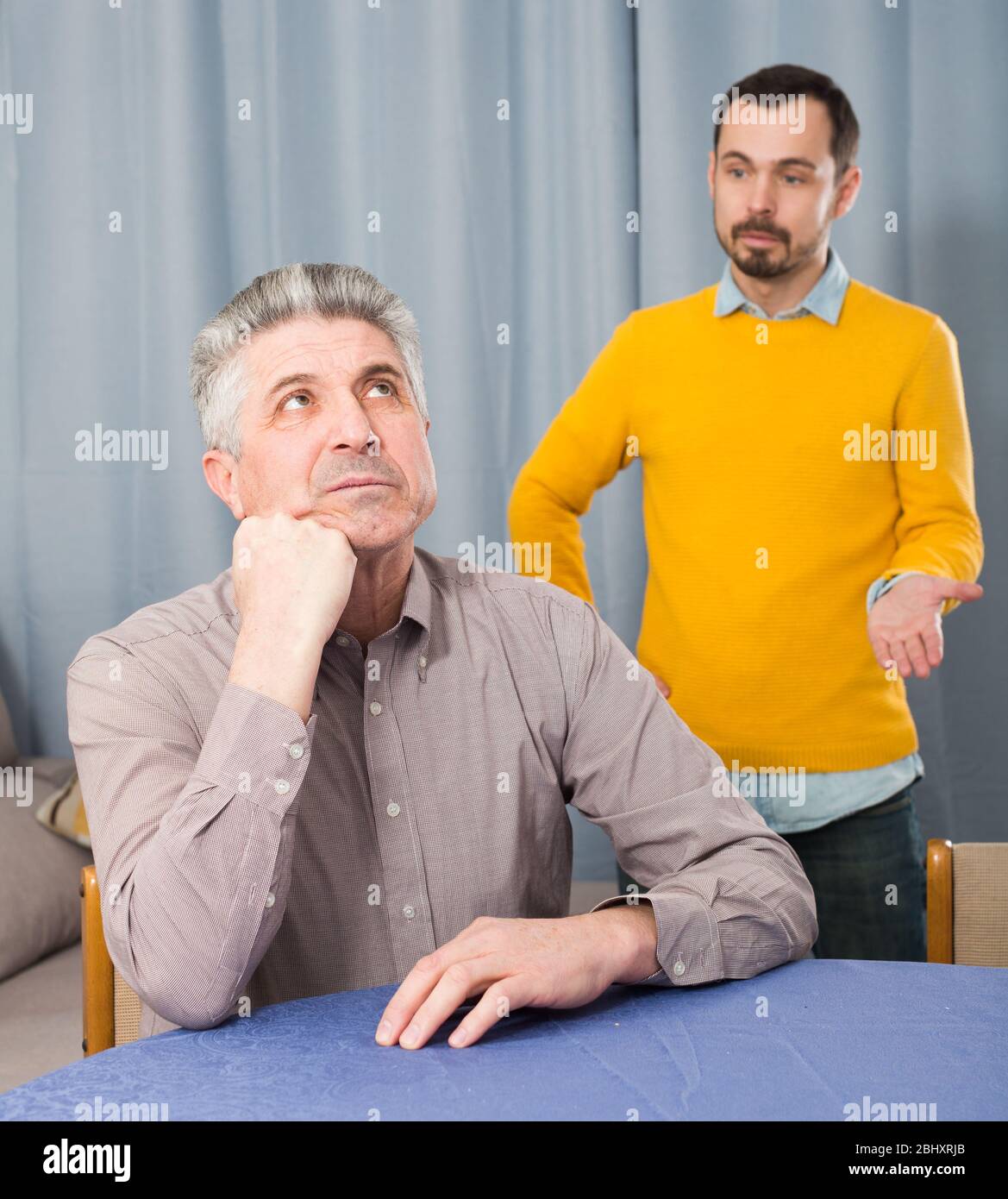 Son defends his position before adult father at home Stock Photo - Alamy