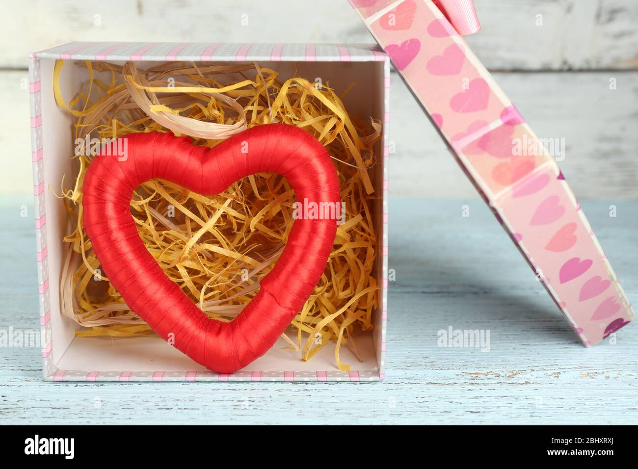 Red heart in present box on wooden table Stock Photo - Alamy
