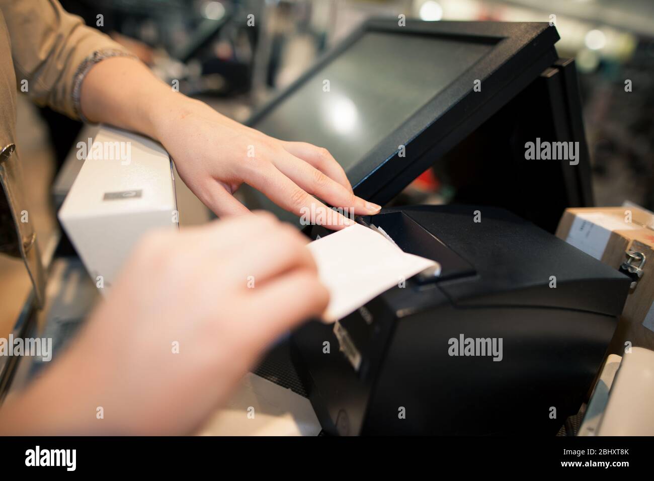 Young woman printing some invoice, receipt for a costumer at huge ...