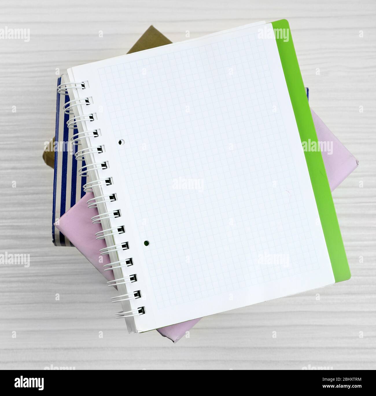 Notebook on top of pile of books and magazines on wooden background ...