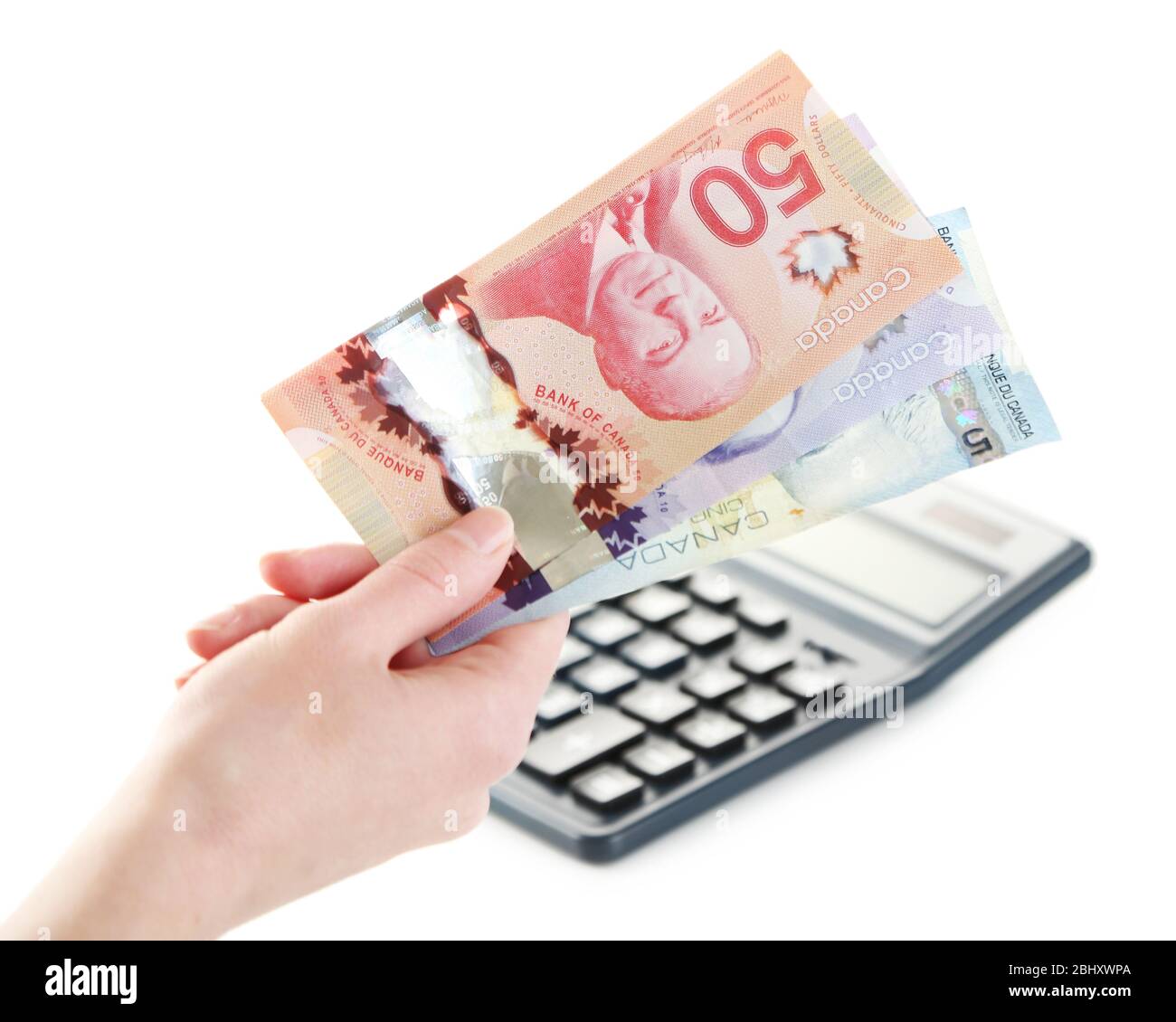 Female hand with Canadian dollars and calculator, isolated on white ...