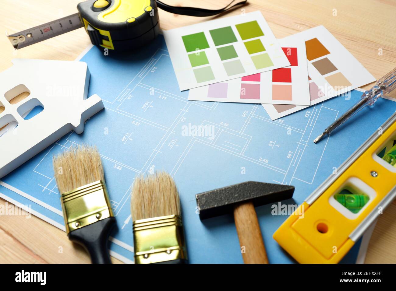 Construction instruments, plan, color samples and brushes on wooden ...