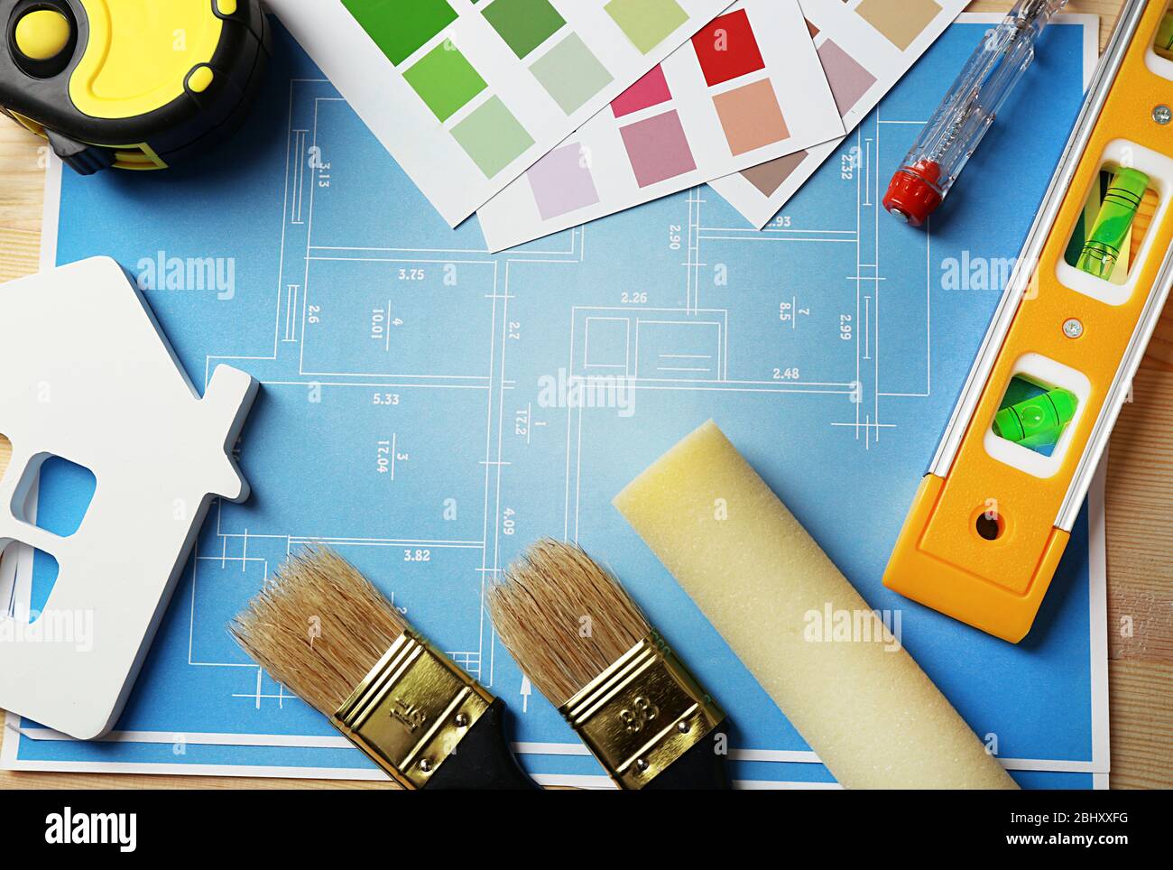 Construction instruments, plan, color samples and brushes on wooden ...