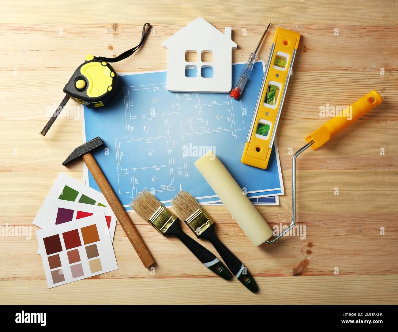 Construction instruments, plan, color samples and brushes on wooden ...