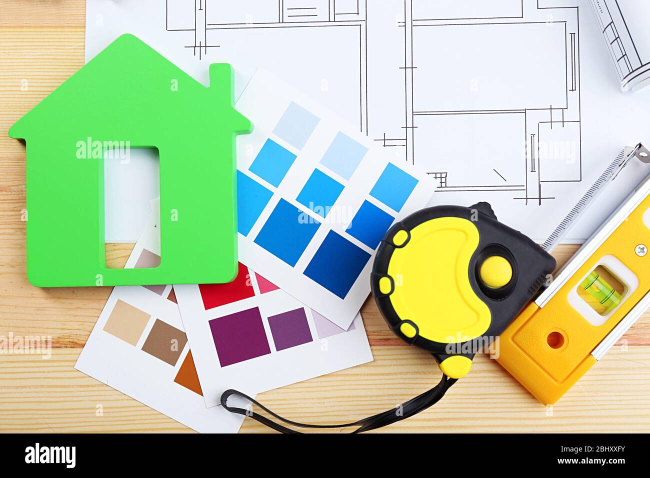 Construction instruments, plan and brushes on wooden table background ...