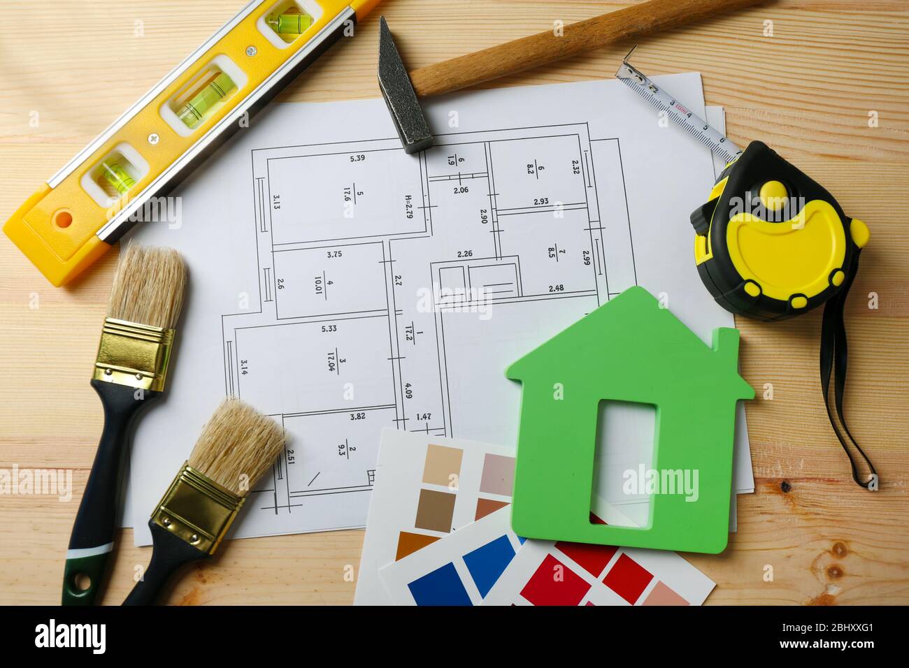 Construction instruments, plan and brushes on wooden table background ...