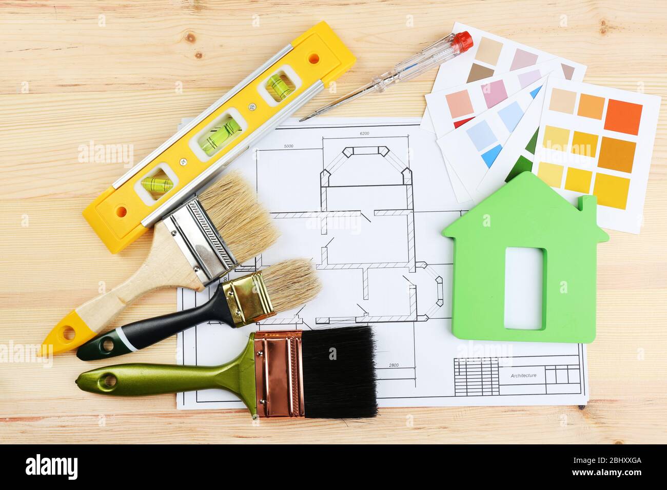 Construction instruments, plan, color samples and brushes on wooden ...