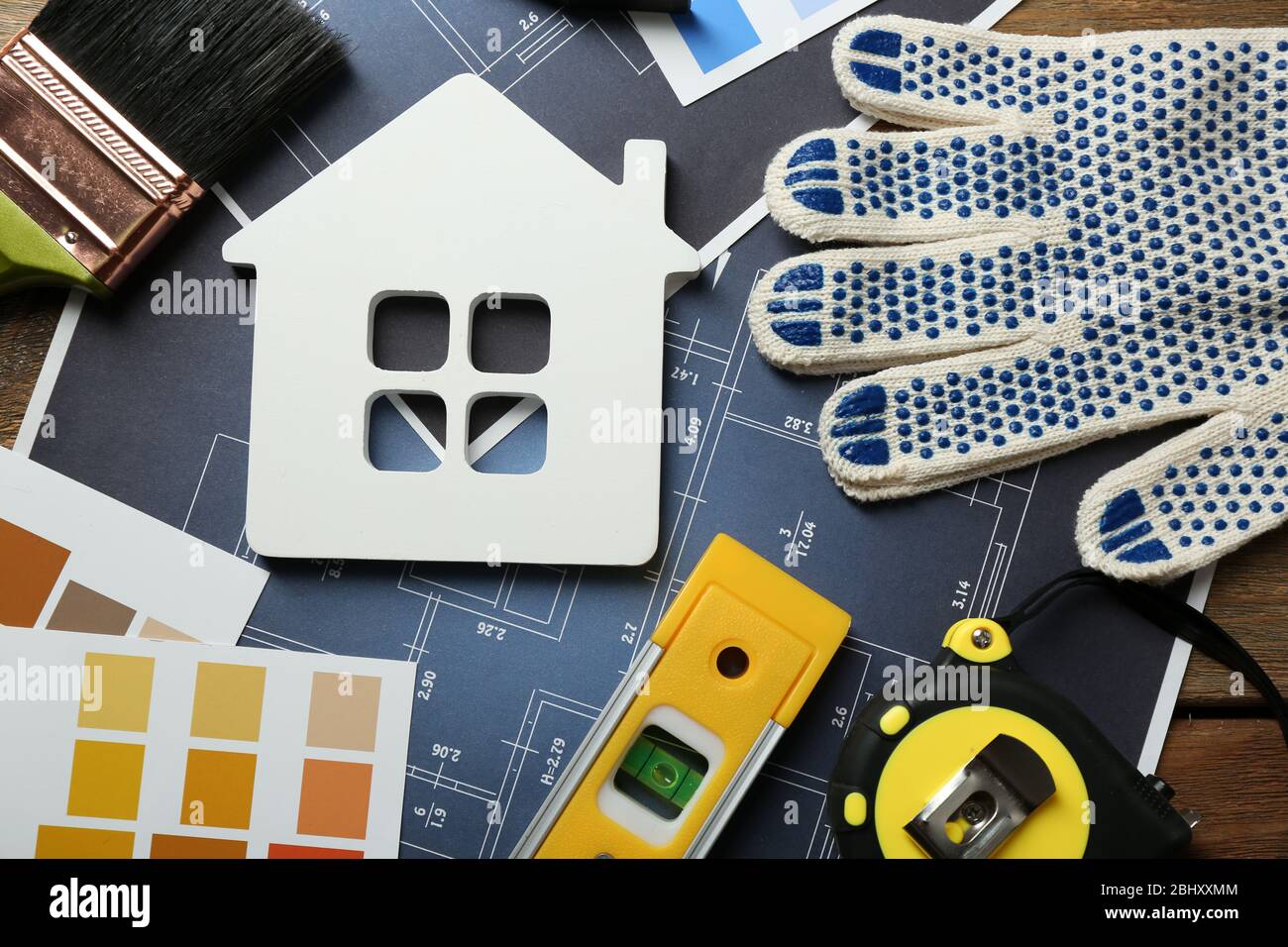 Construction instruments, plan and brushes on house plan background ...