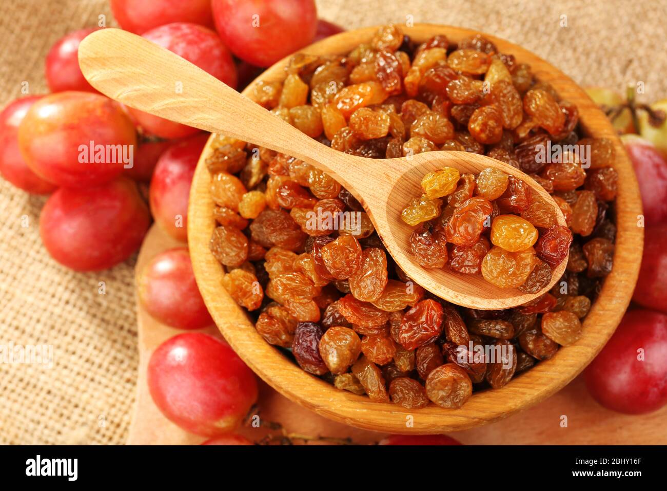 Raisins in bowl with grapes on table close up Stock Photo - Alamy
