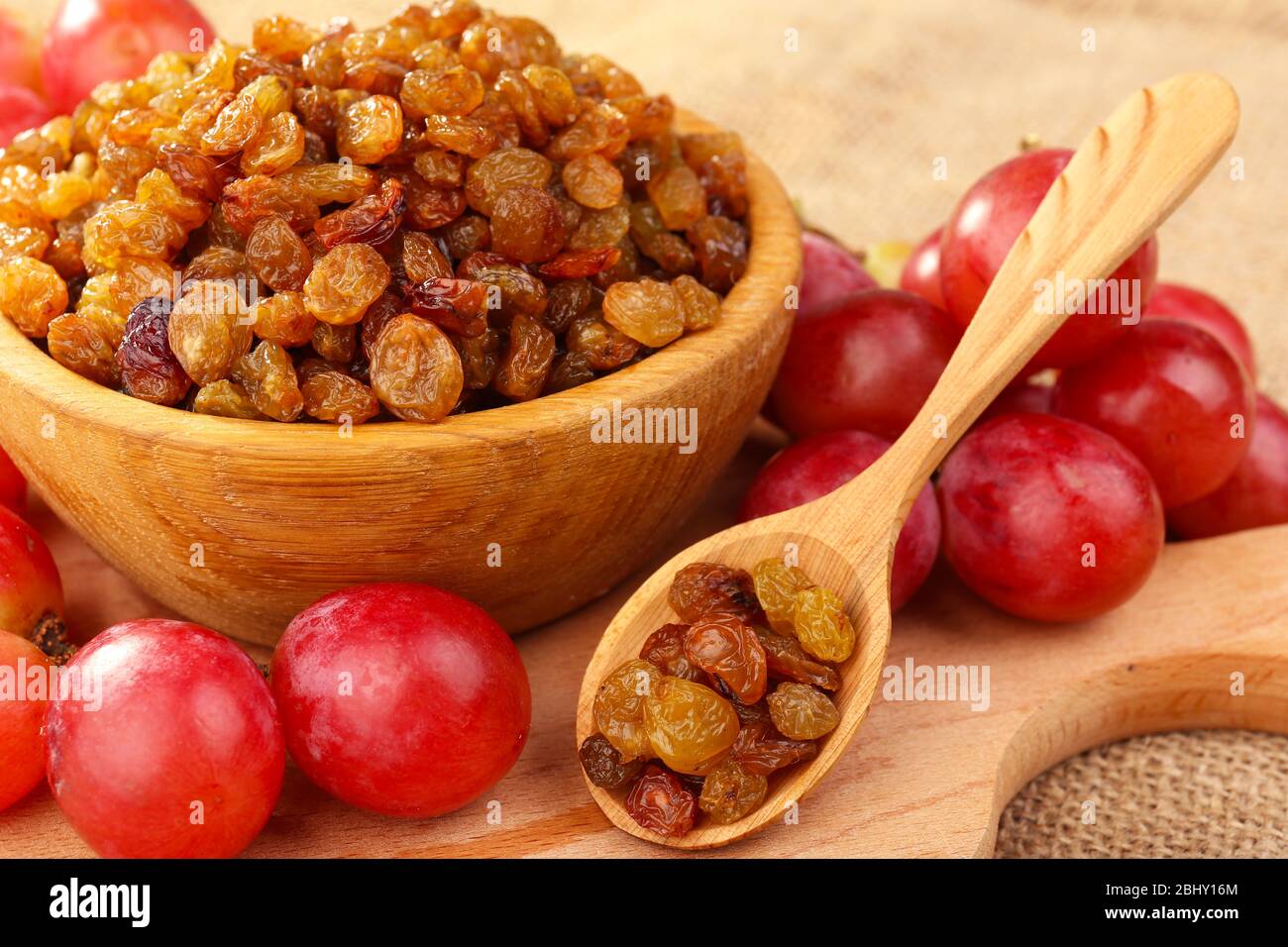 Raisins in bowl with grapes on table close up Stock Photo - Alamy