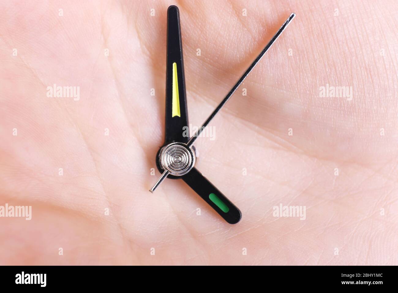 Hand holding clock arrows close up Stock Photo - Alamy