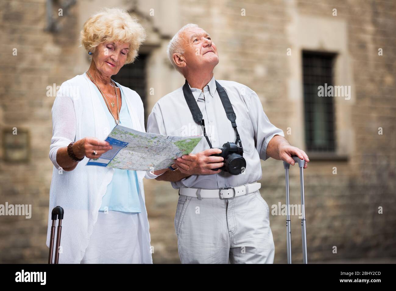 Happy travellers with suitcases visiting sights of European city with ...