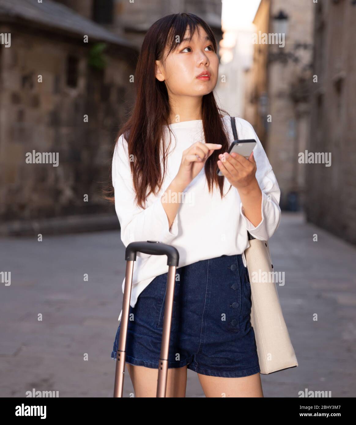 Young chinese female is looking up the way in phone by using gps Stock ...