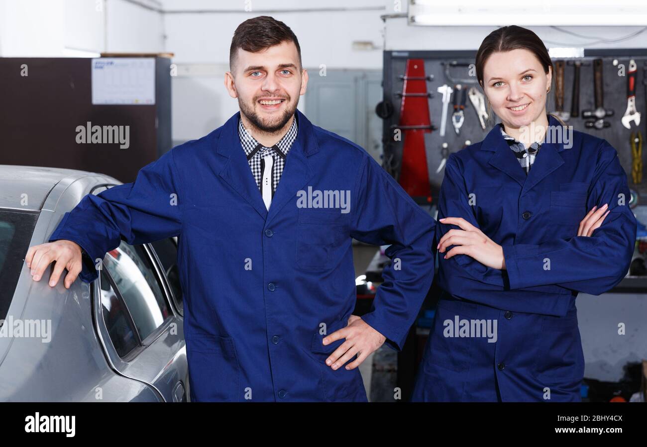 Two young masters are standing on their workplace in workshop Stock ...