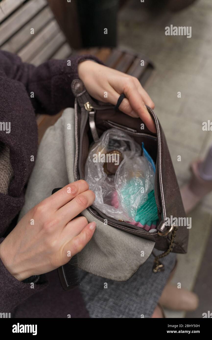 mess in a woman’s handbag. female hands opened a little bag in which a ...