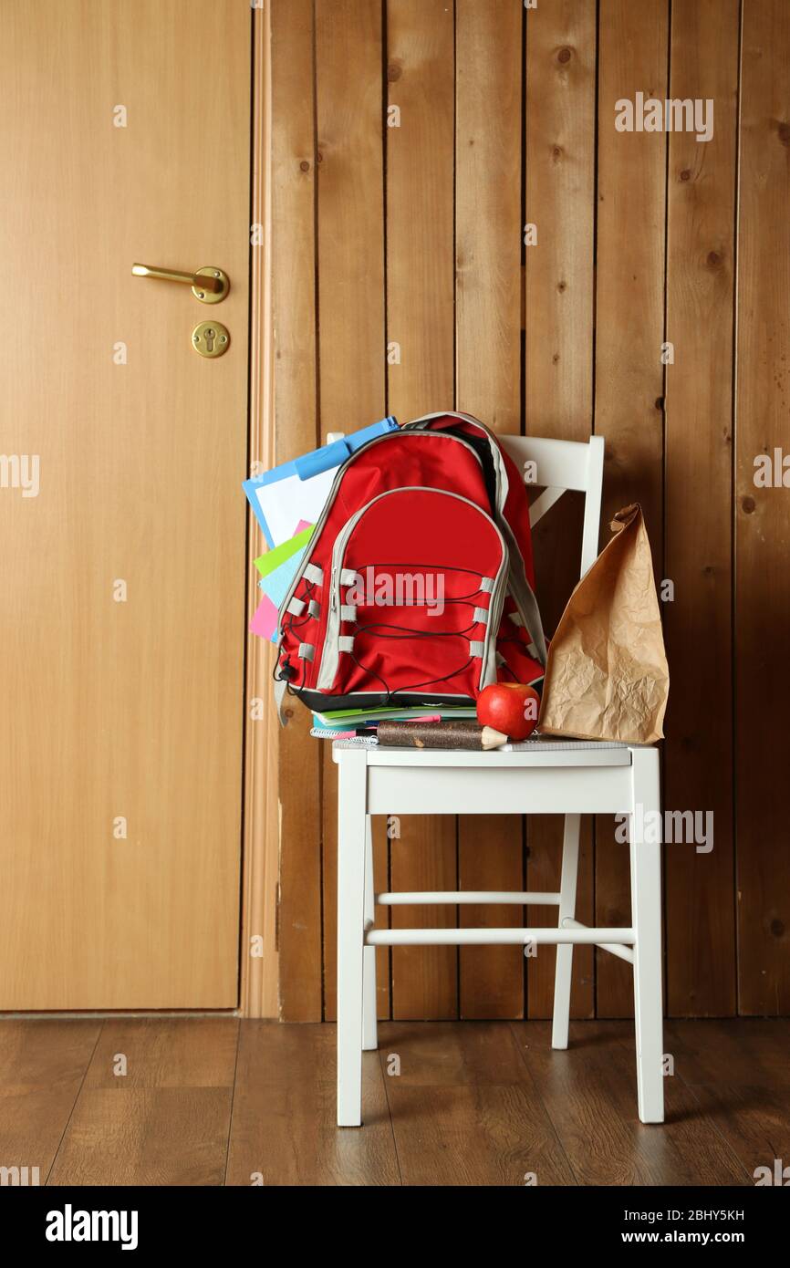 Backpack with school supplies on chair on wooden background Stock Photo ...