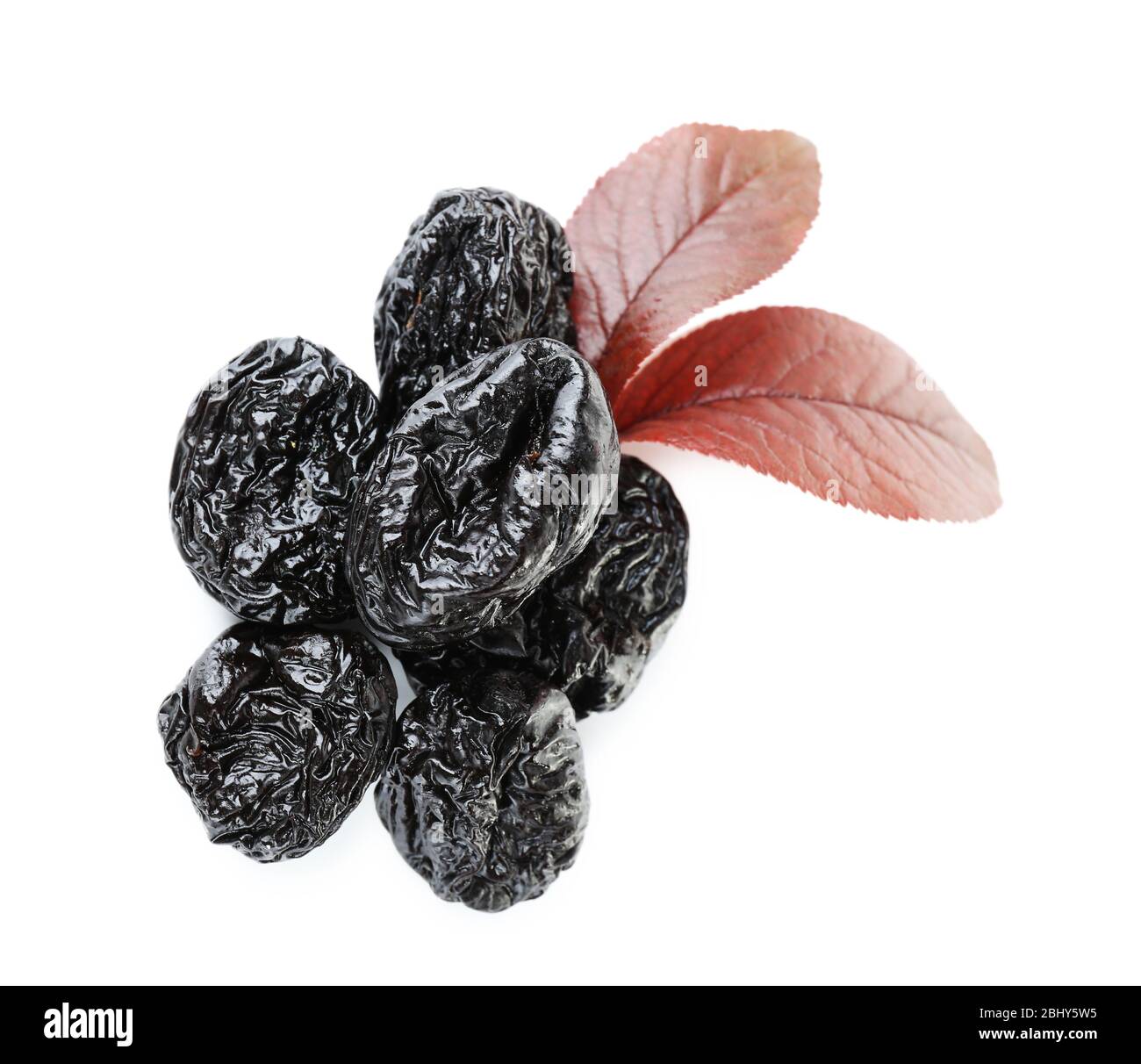 Pile of prunes with leaves isolated on white Stock Photo - Alamy