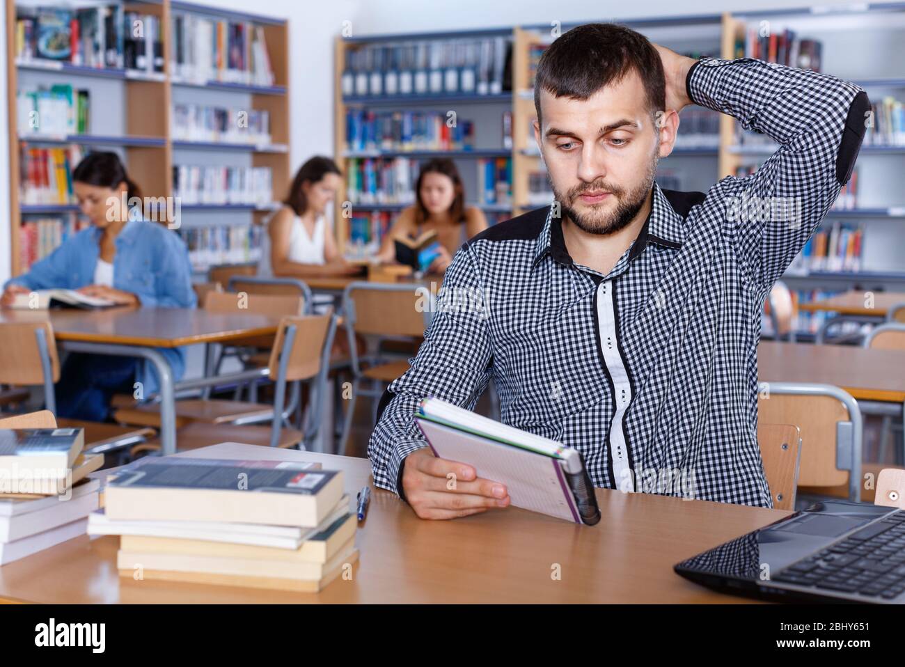 Portrait of upset unhappy pleasant tired male student preparing for ...