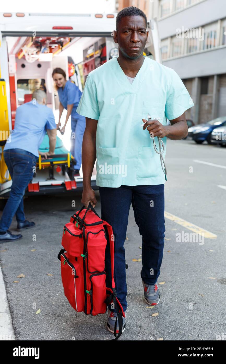 professional emergency team going to call with medical equipment ...