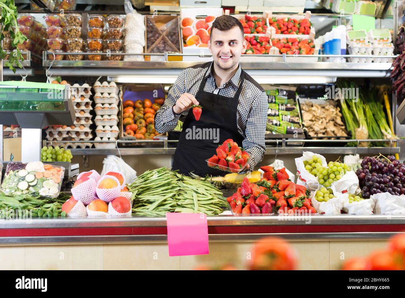 happy english male shopping assistant demonstrating assortment of ...