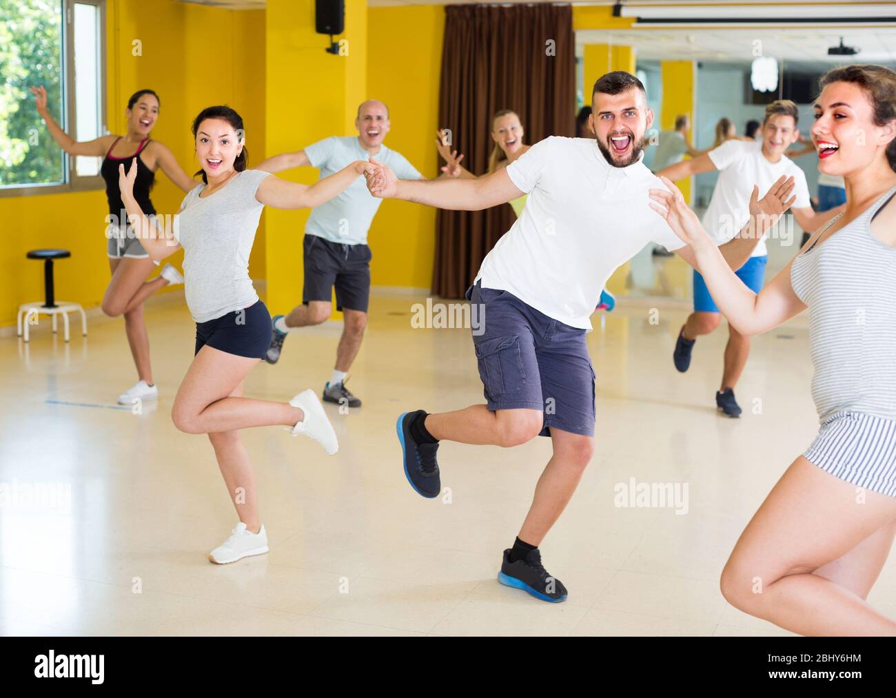 Positive women and men are dancing boogie-woogie in pairs in modern ...